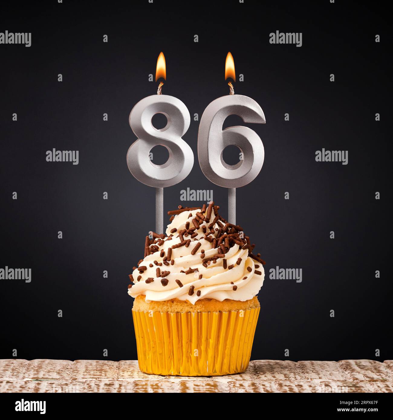 birthday cupcake with number 86 candle - Celebration on dark background ...