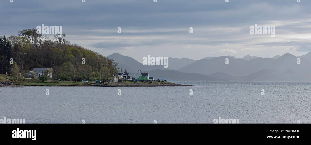 Looking out at a Scottish headland across the sea the mountains of the ...