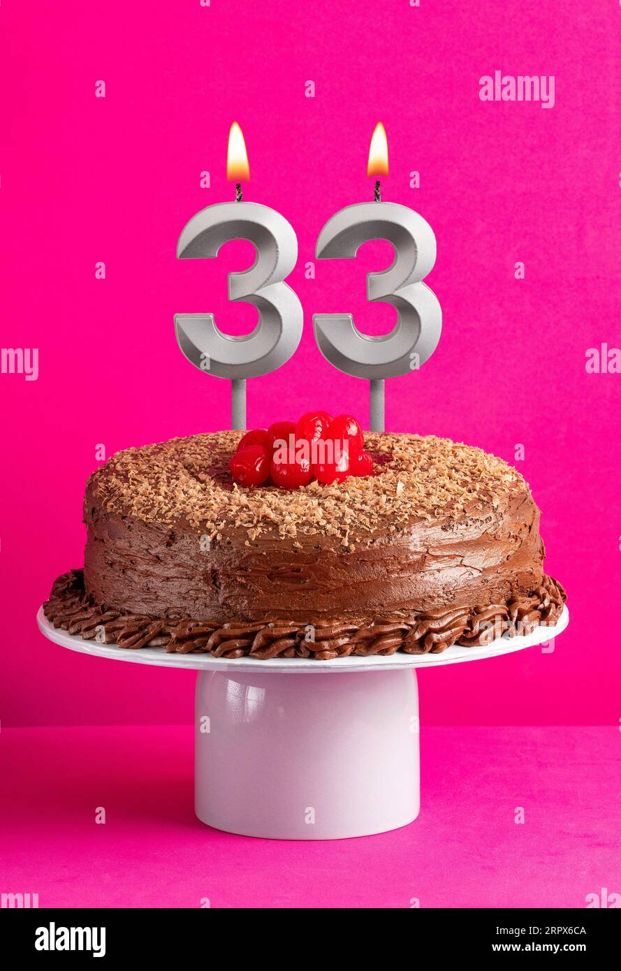 Number 33 candle - Chocolate cake on pink background Stock Photo - Alamy