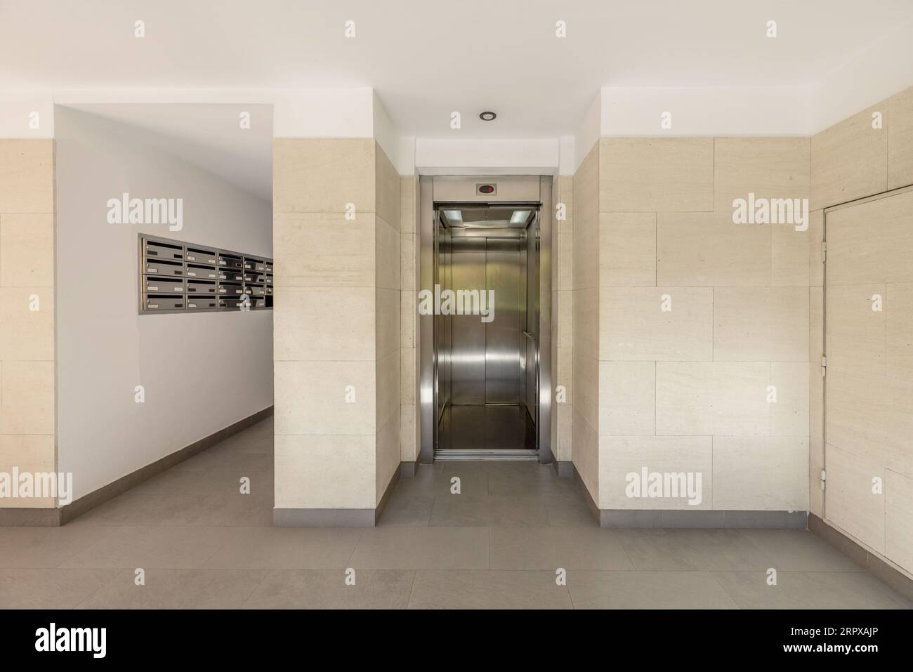 Access portal of a building with cream-colored tiling and a stainless ...