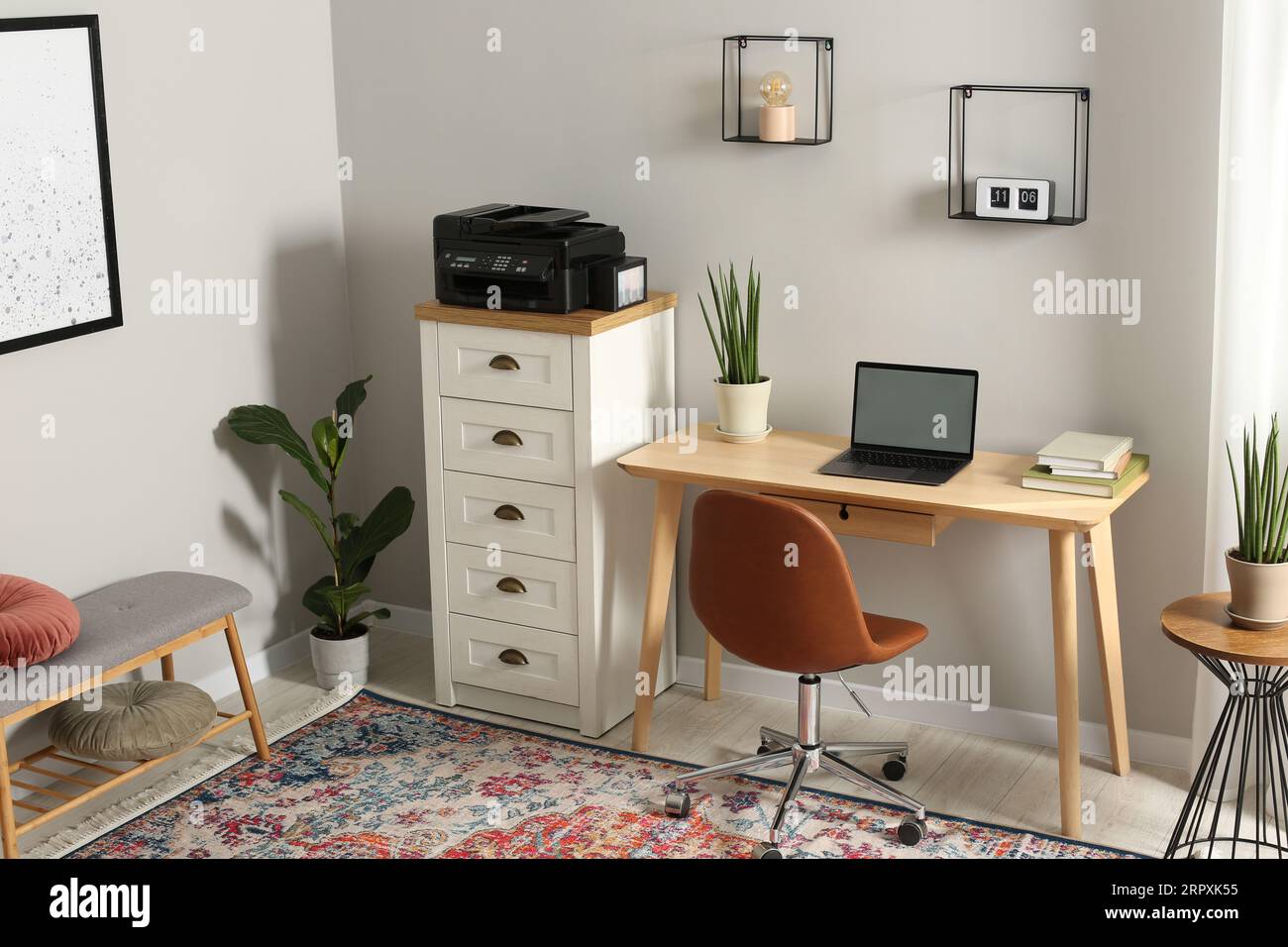 Stylish room interior with chest of drawers, modern printer and laptop ...