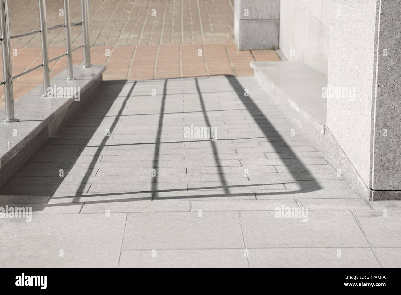 Tiled ramp with metal handrail near building outdoors Stock Photo - Alamy