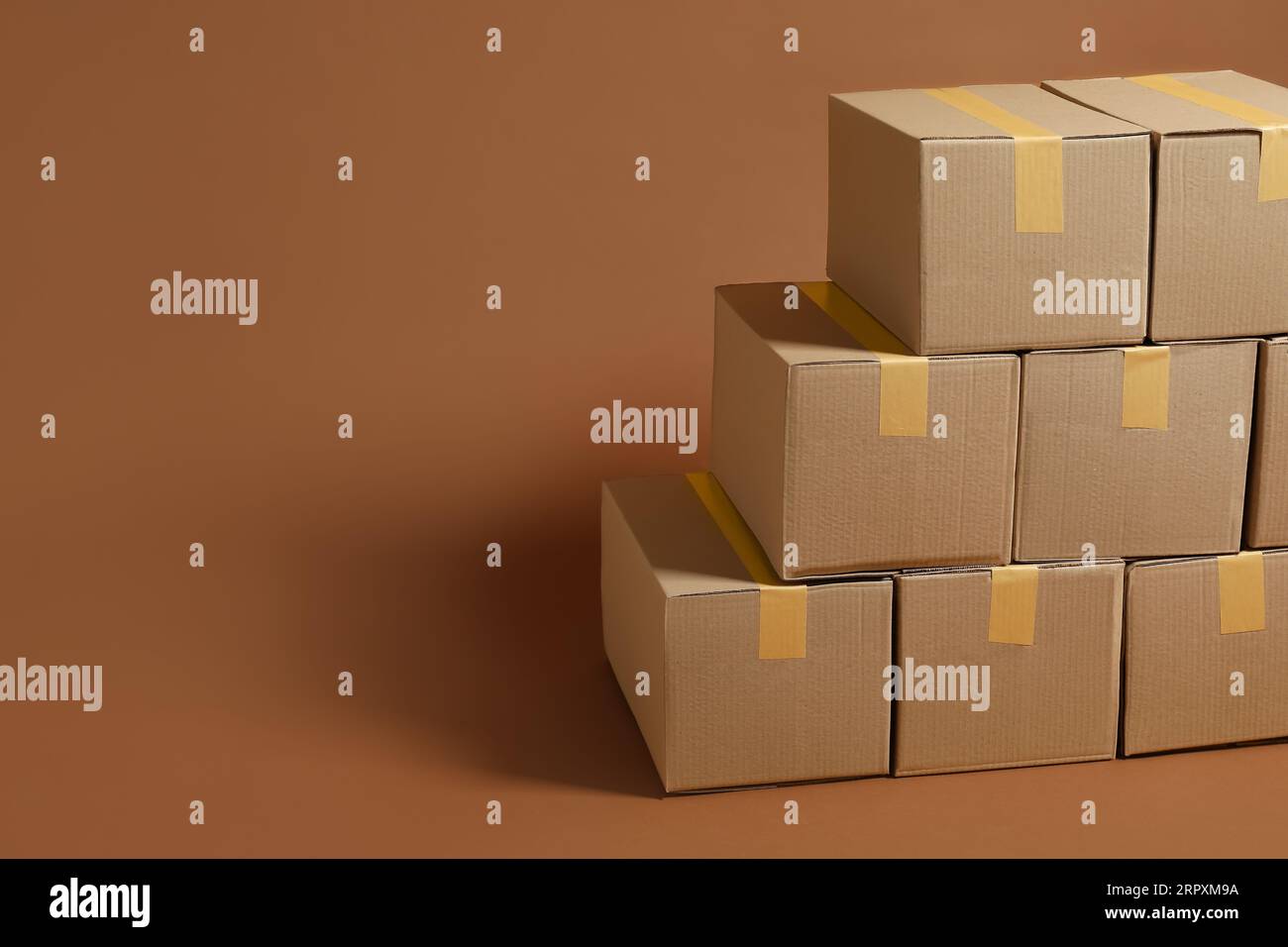 Stack of many cardboard boxes on brown background, space for text Stock ...