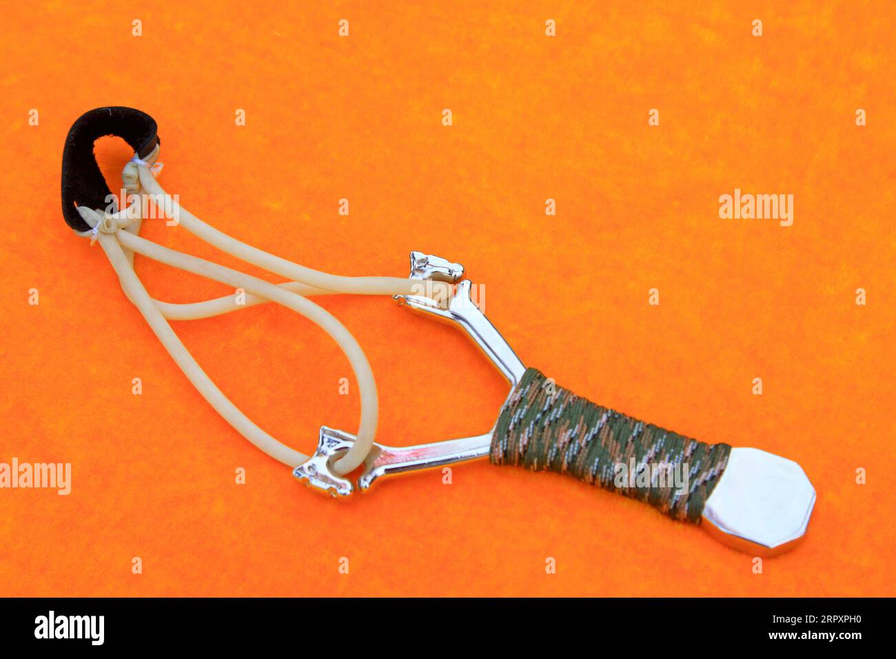 slingshot made by iron wire in orange background Stock Photo - Alamy