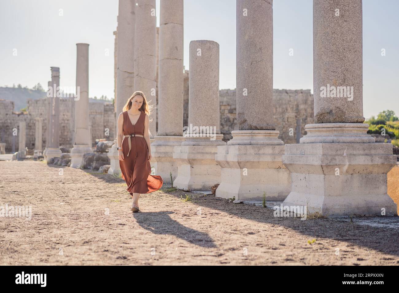 Pretty tourist woman at the ruins of ancient city of Perge near Antalya ...
