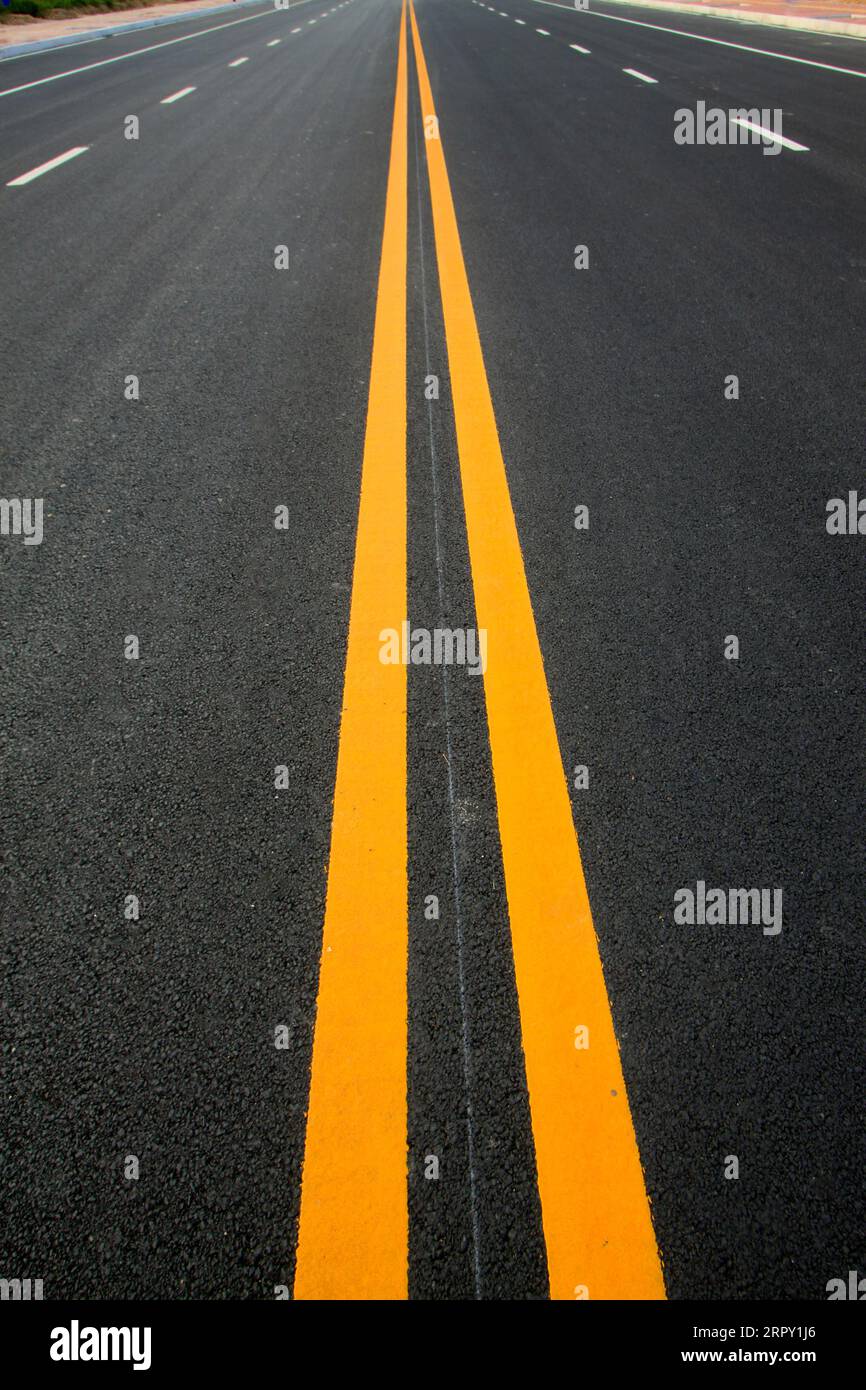 Double yellow lines on the asphalt road, closeup of photo Stock Photo ...
