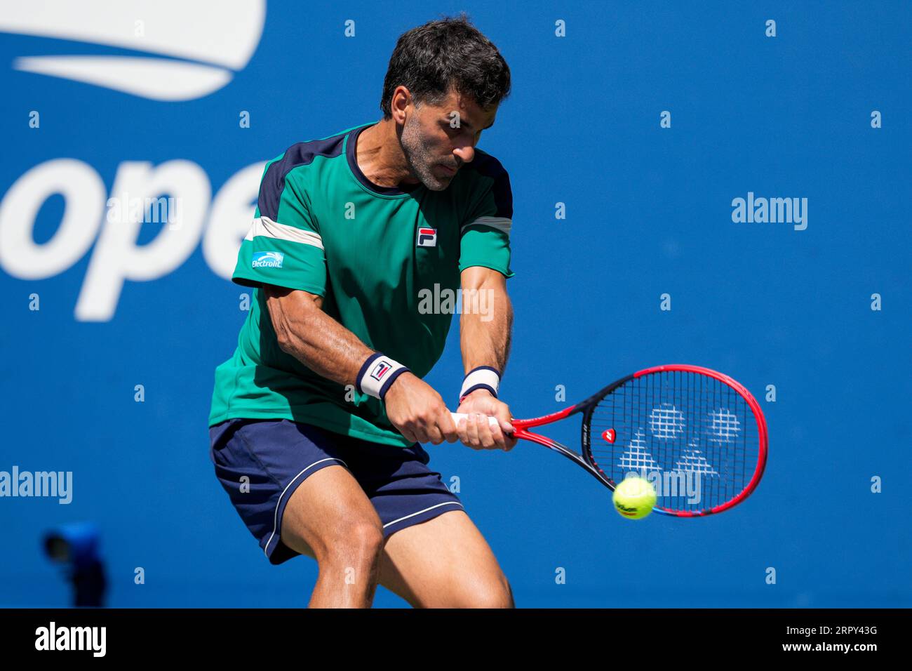 Maximo Gonzalez hits a backhand during a men's doubles quarterfinal ...