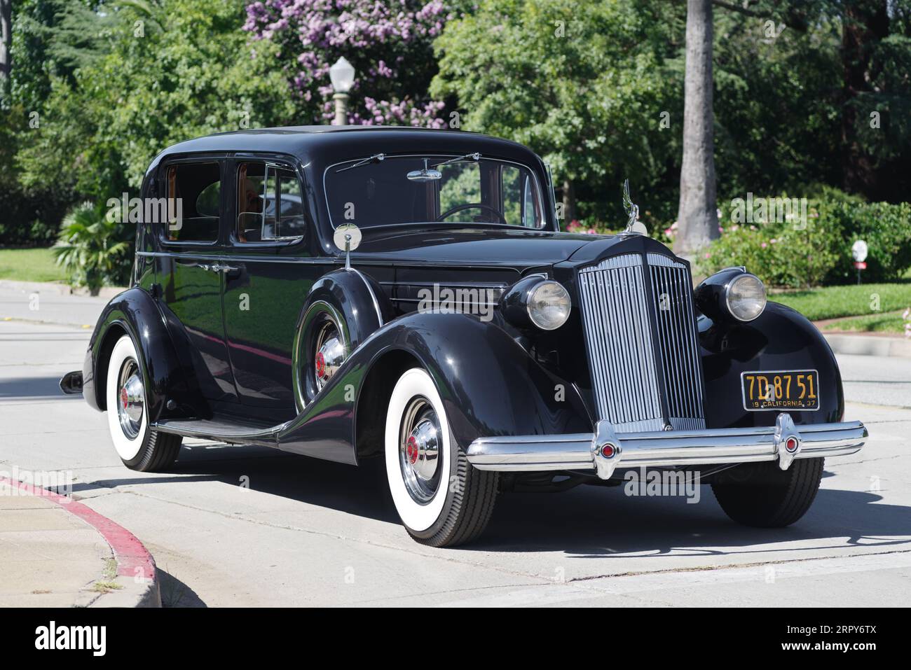 Packard automobile shown driving in a residential area on a sunny ...