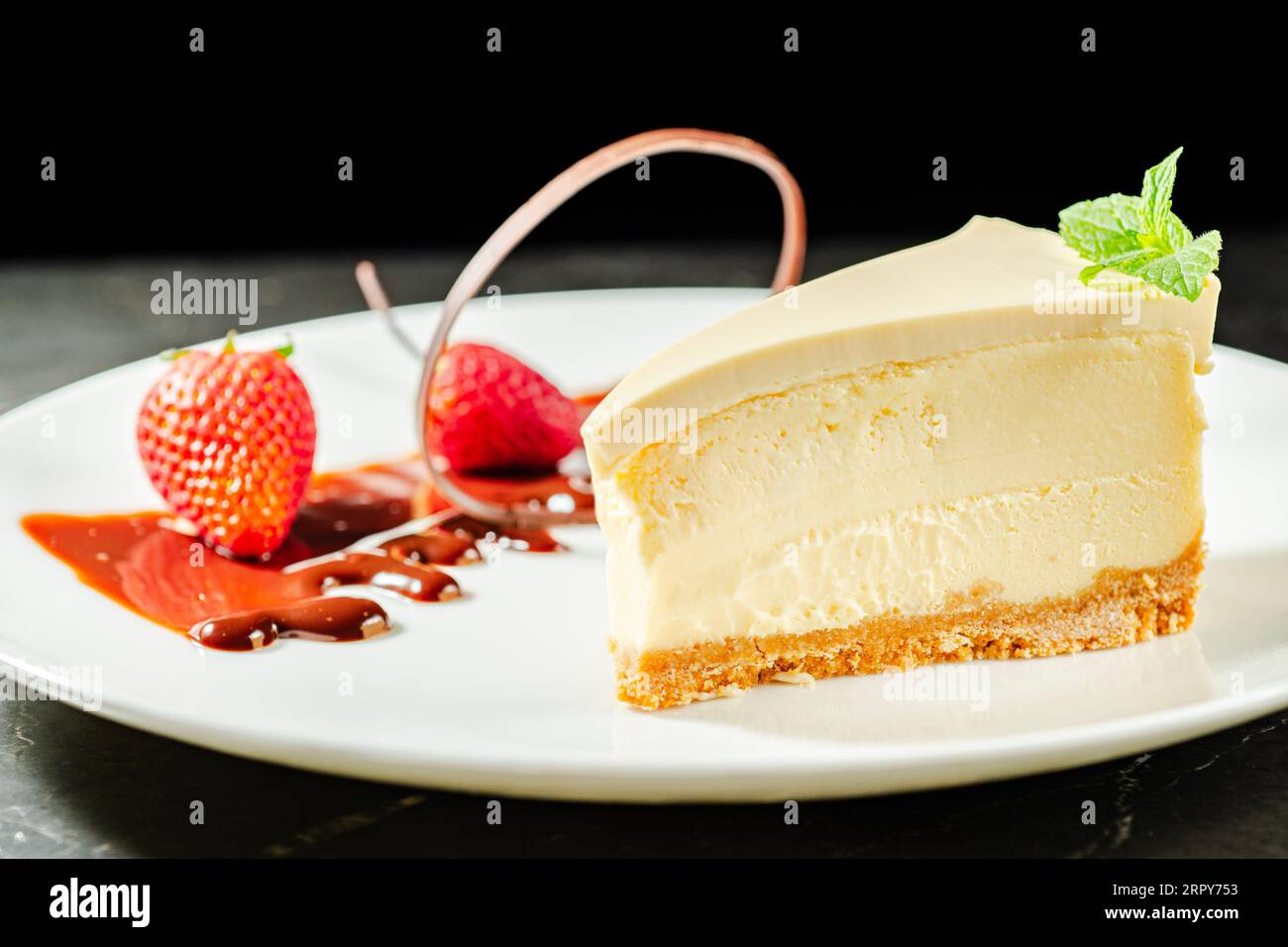 Plated dessert with a rich cheesecake and a creamy Vanilla Panna Cotta ...