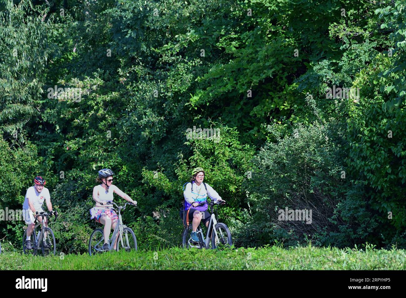 Glen Ellyn, Illinois, USA. A trio of cyclists riding along the Illinois ...