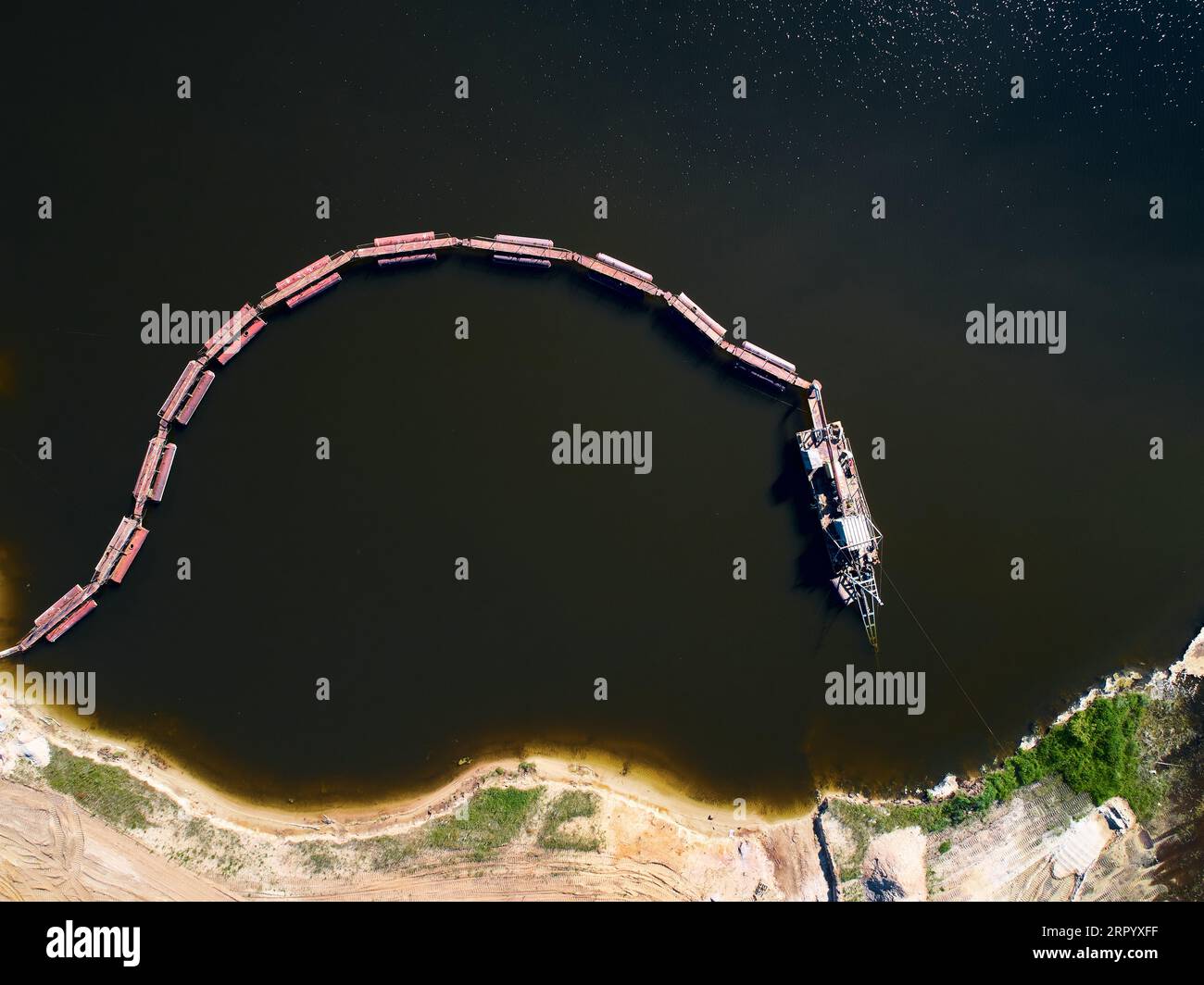 Suction tube dredger draws up mud from pond bottom at bank Stock Photo ...