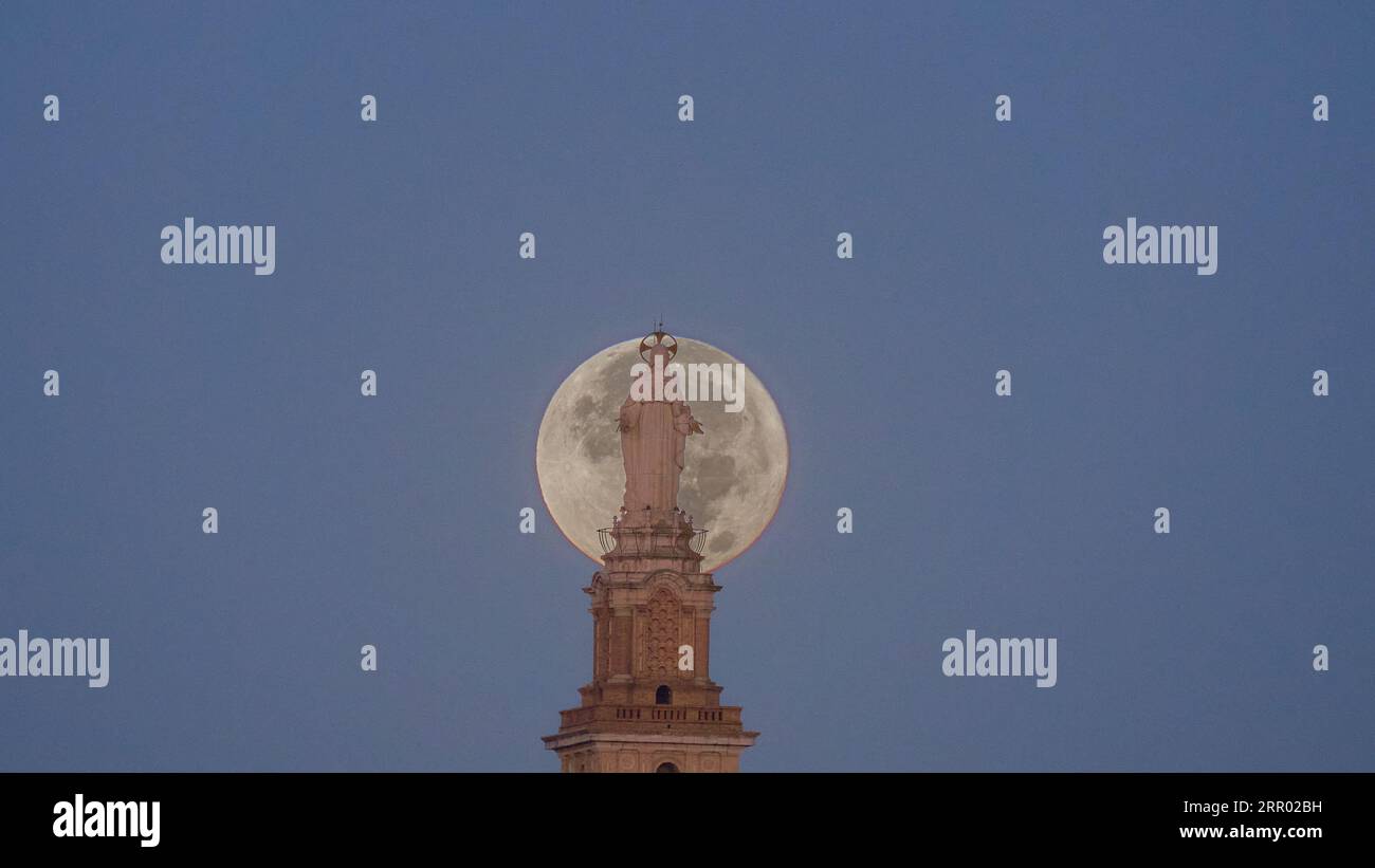 A closeup of a full moon behind the image of the sacred heart of Jesus ...