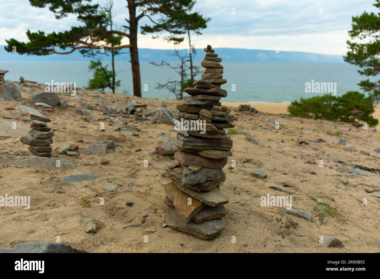 Zen Pyramid Stones and Larches on the Baikal Sand Beach Stock Photo - Alamy