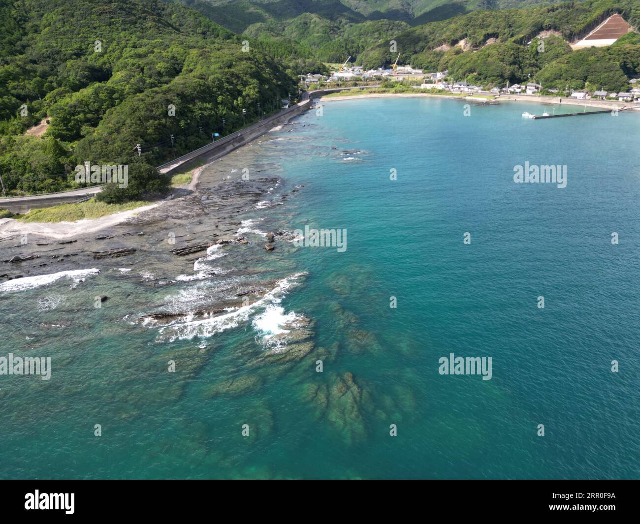 Aerial view of a coastal landscape featuring lush green mountains at ...
