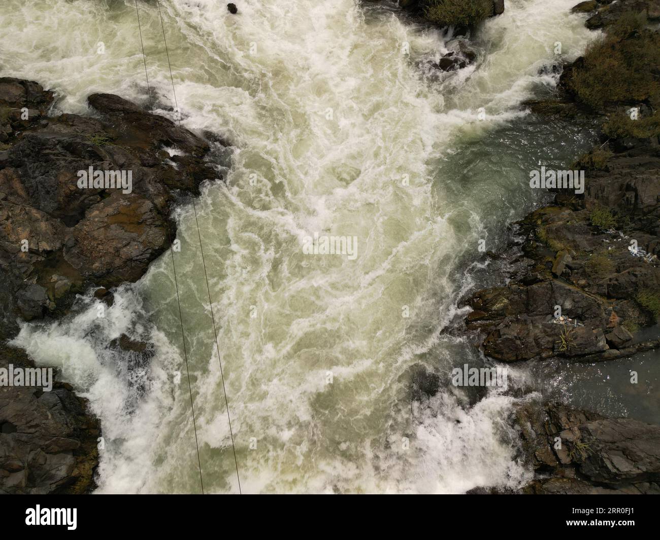 Aerial view of a lush mountainous landscape in Laos featuring a fast ...