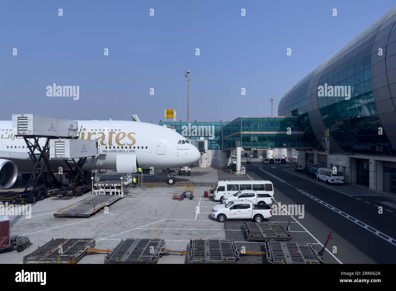 An airplane of Emirates airlines attached to a jet bridge walkway ...