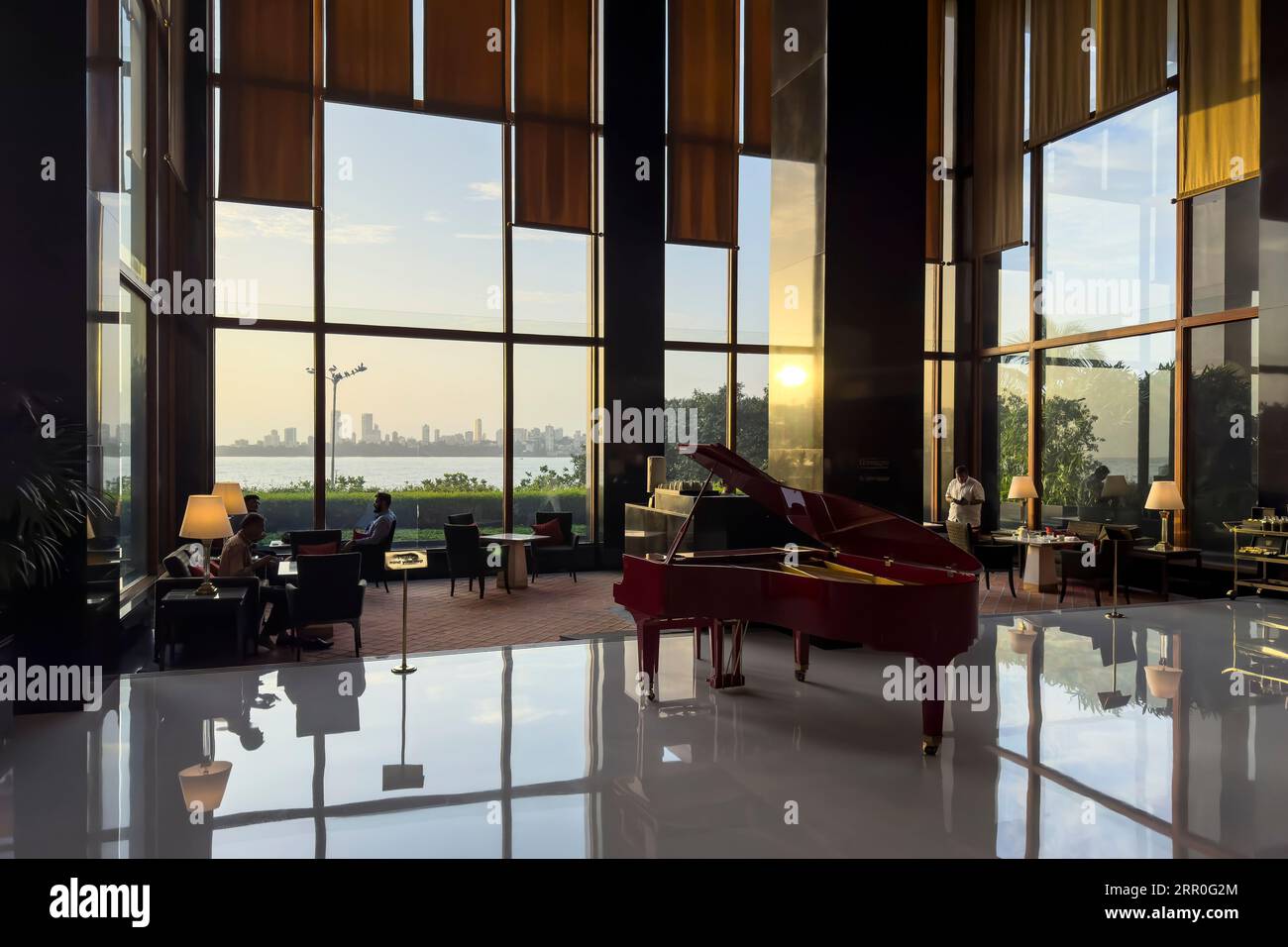 People sit in the lobby of the Trident hotel located in Nariman Point ...