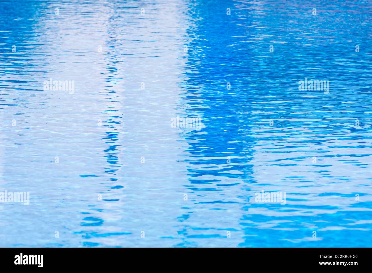 White buildings giving abstract reflections in blue swimming pool water ...
