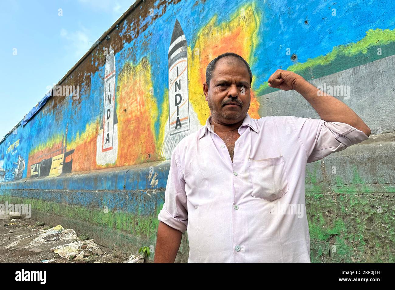 A local man stands with victorious expression next to a painted wall ...