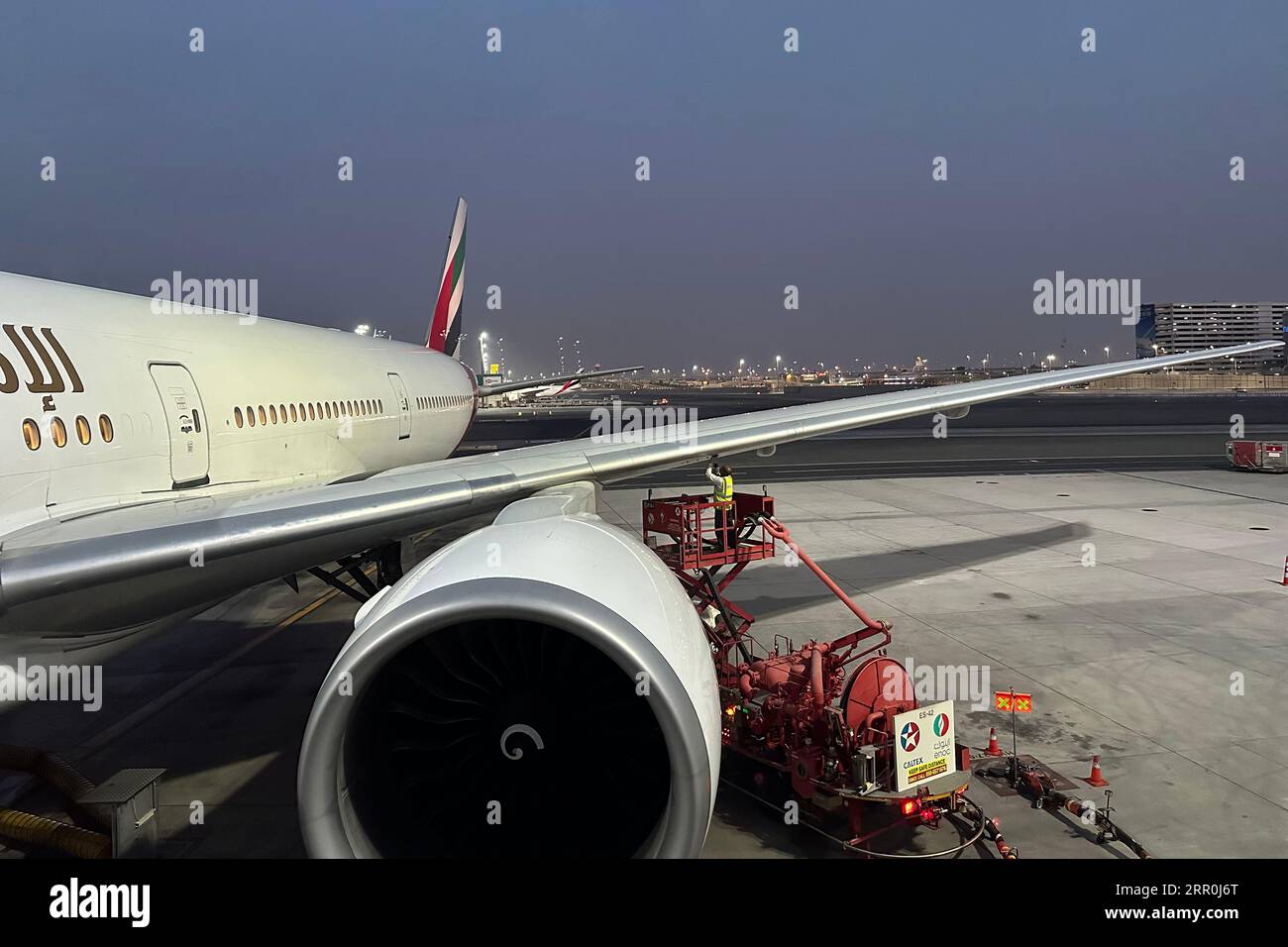 A worker checks the wings of an airplane of Emirates airlines standing ...