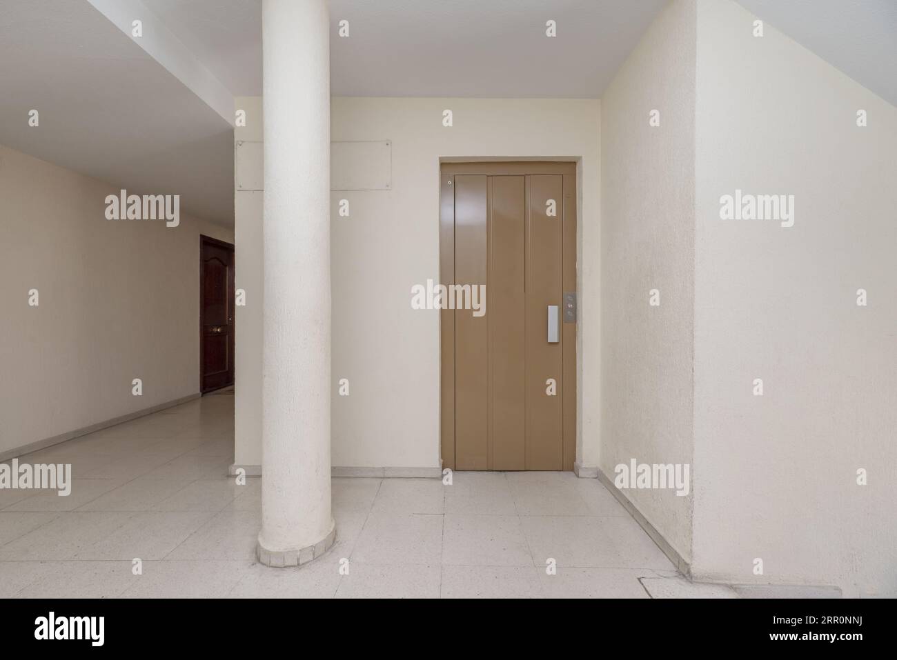 Access portal to building with walls painted in cream color and steel ...