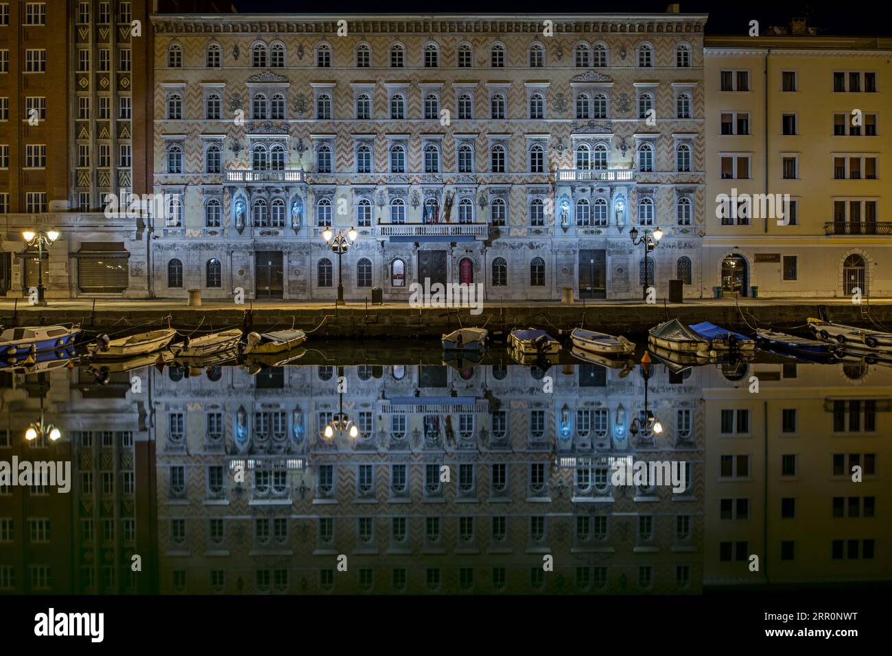 Night view of the facade of a vintage building with its reflection in ...