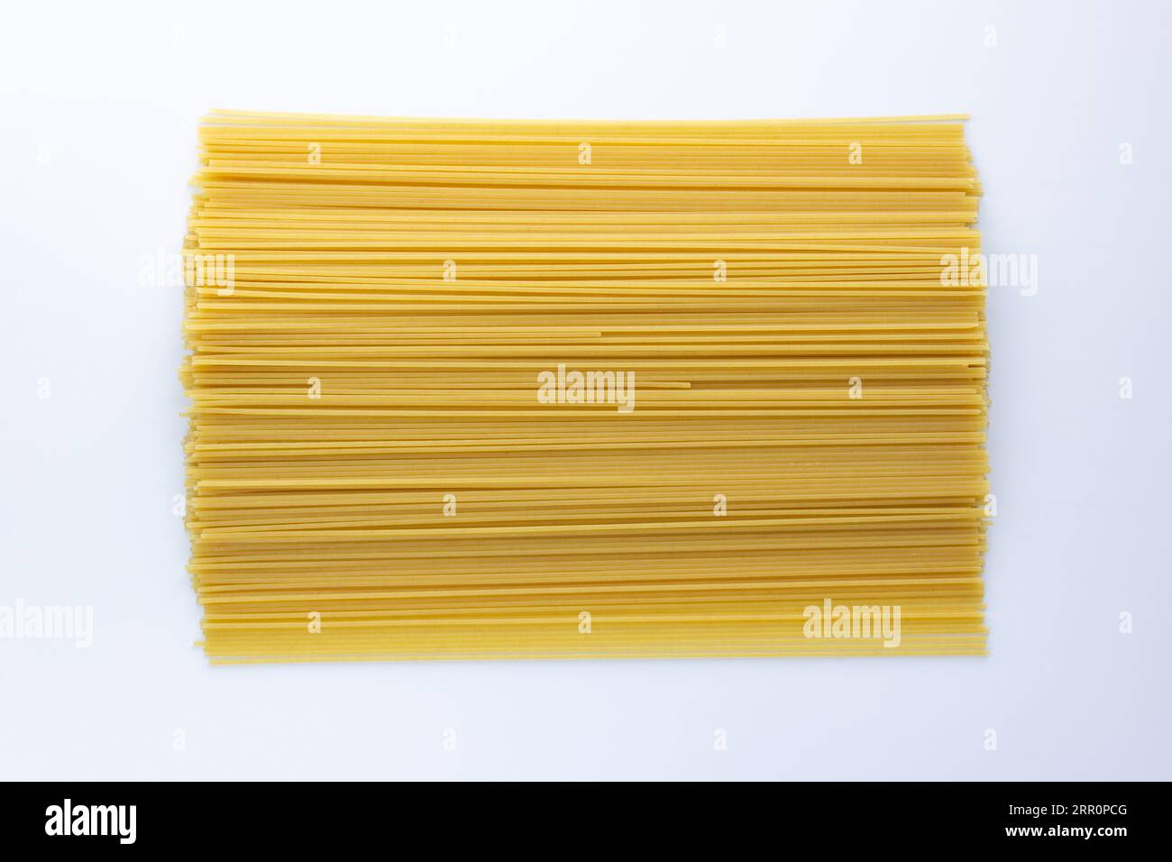Bright yellow spaghetti on a white background laid out horizontally ...