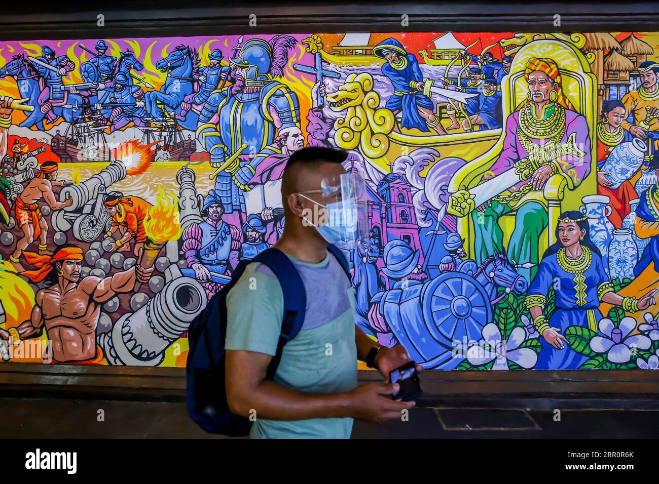 200824 -- MANILA, Aug. 24, 2020 -- A man walks past a mural at the ...