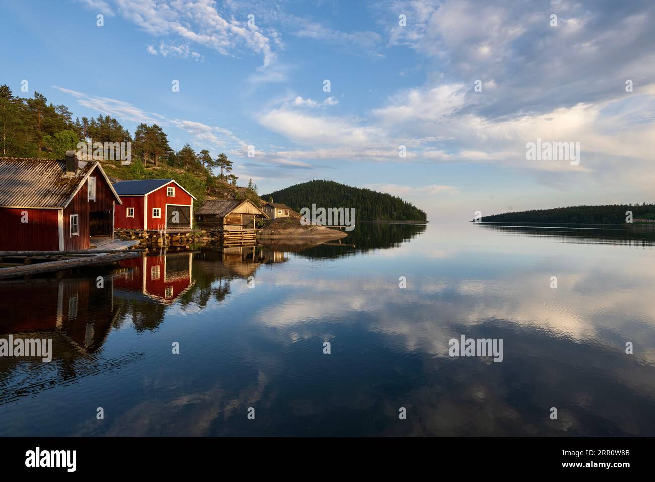 An idyllic landscape featuring a tranquil body of water lined with a ...