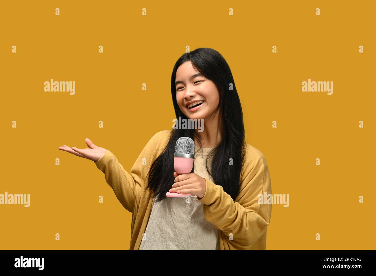 Happy teenage girl singing songs with microphone, posing isolated on ...