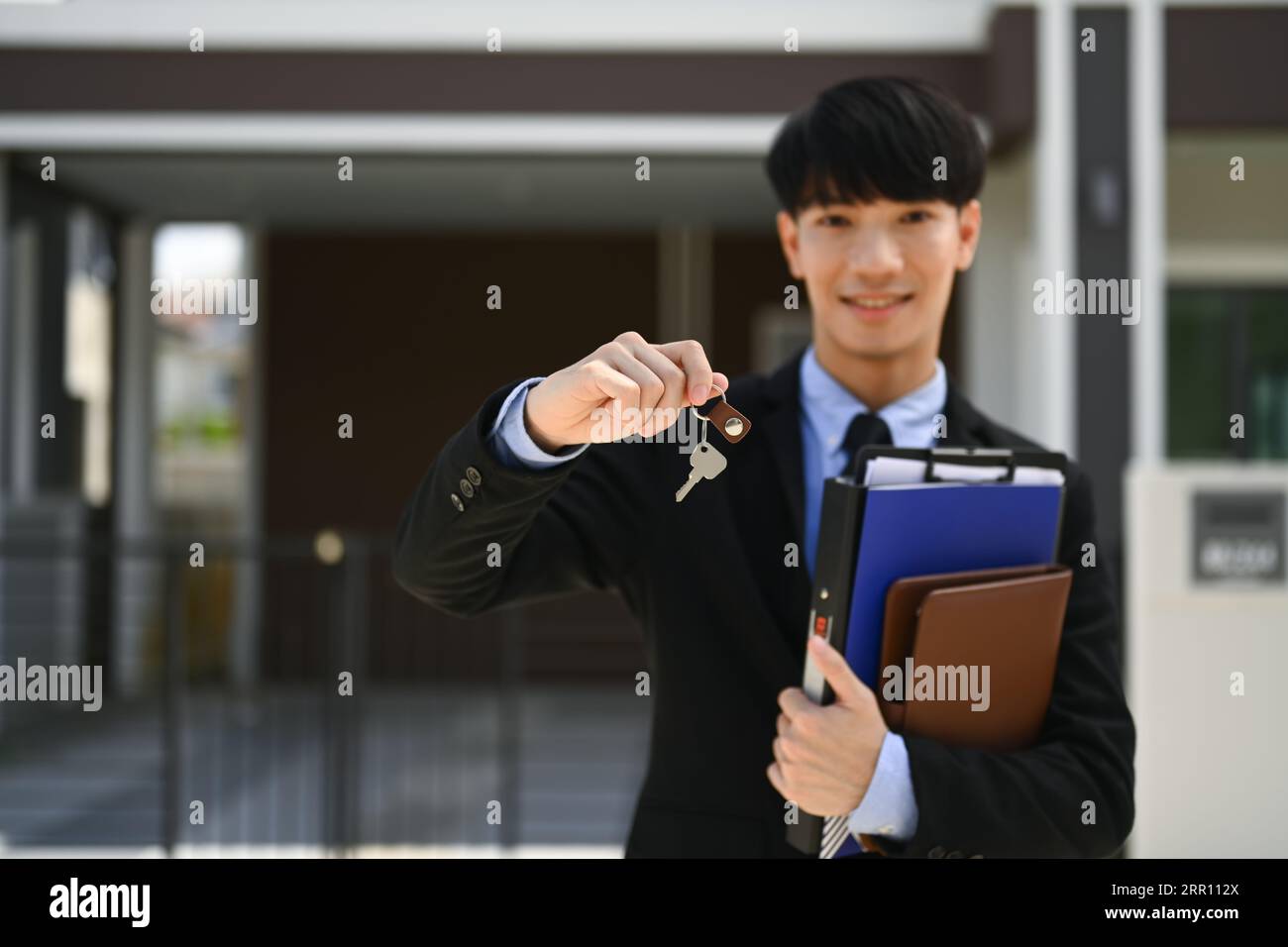 Realtor hands holding keys standing in front of new house. Real estate ...
