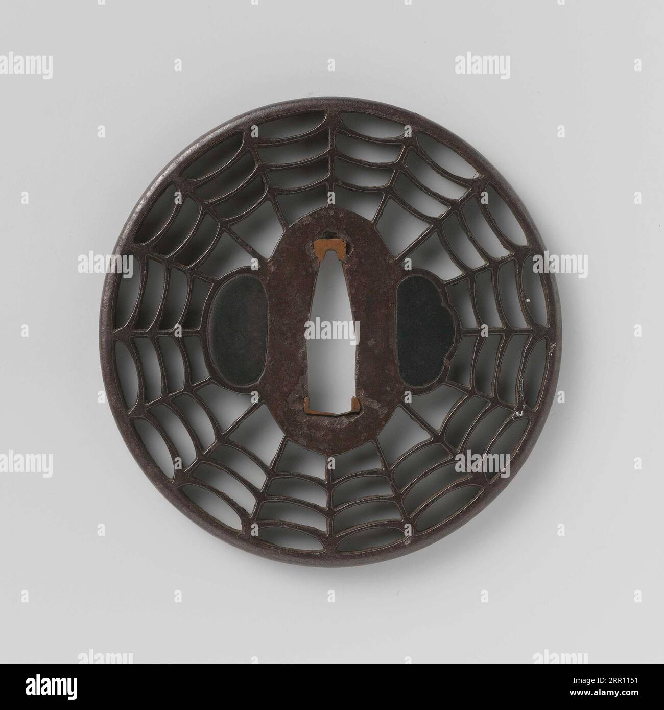 A round oval Iron Tsuba, a sword guard and part of a sword mounting. It ...