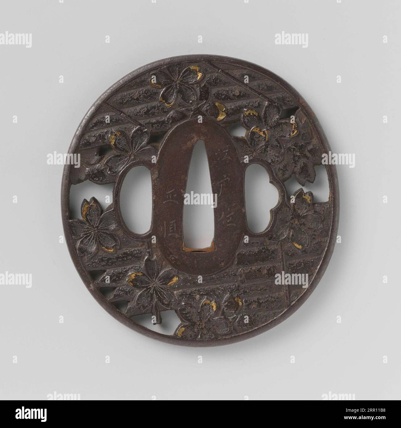 A round oval Iron Tsuba, a sword guard and part of a sword mounting. It ...