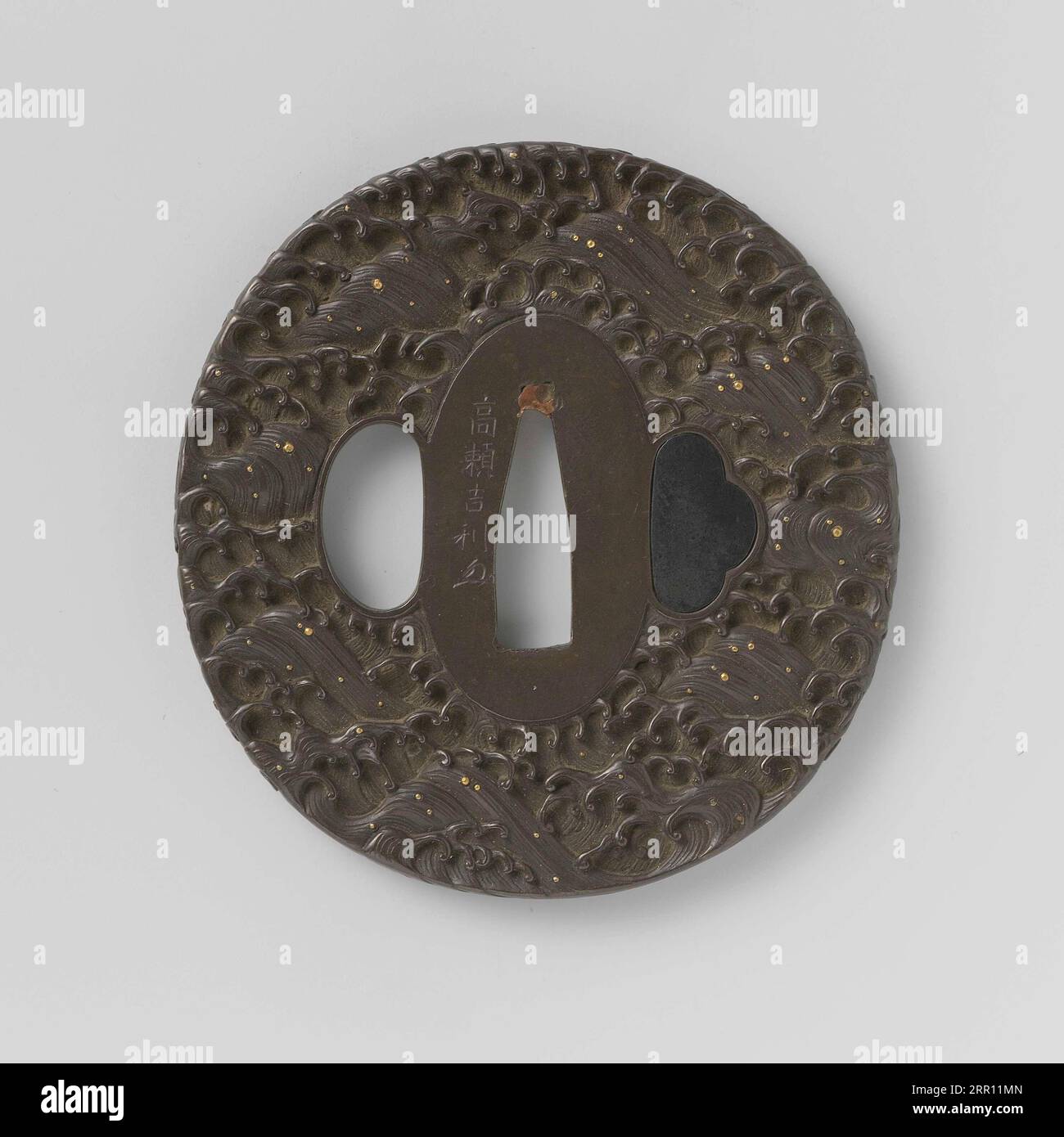 A round oval Iron Tsuba, a sword guard and part of a sword mounting. It ...