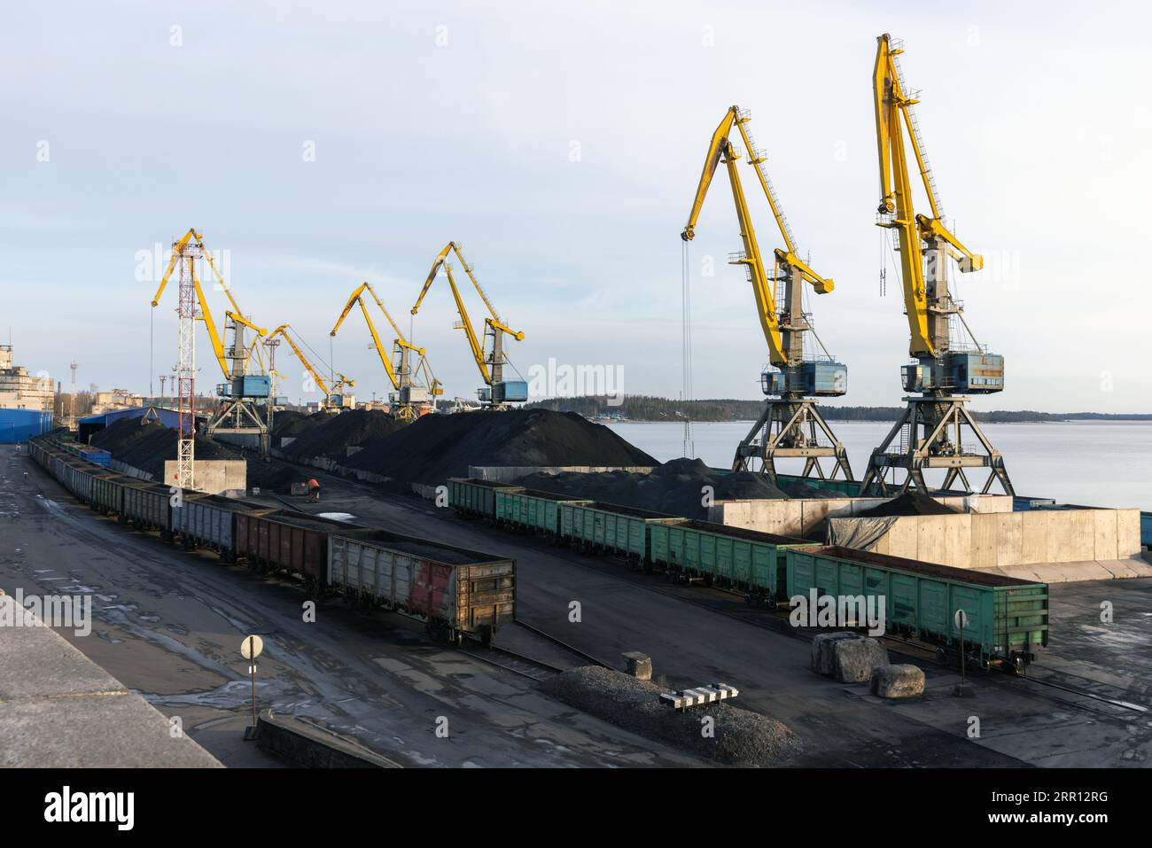 Coal terminal Vyborg. Cranes and railway cars are located on the shore ...