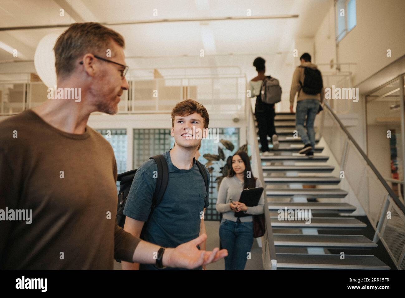 Mature professor explaining student while walking in university Stock ...