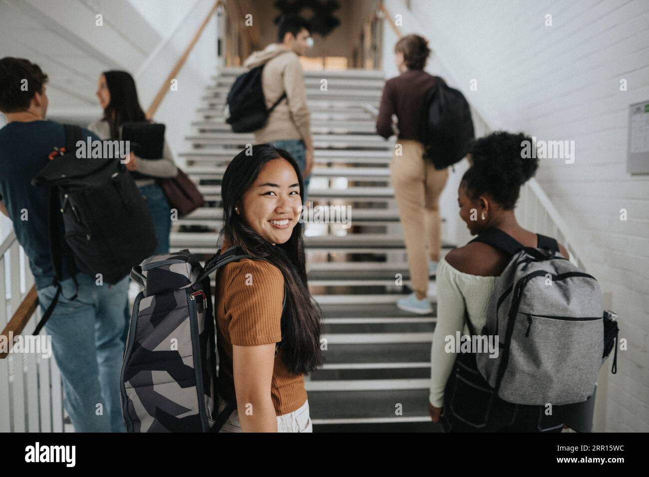 Portrait of happy female student with multiracial friends at university ...