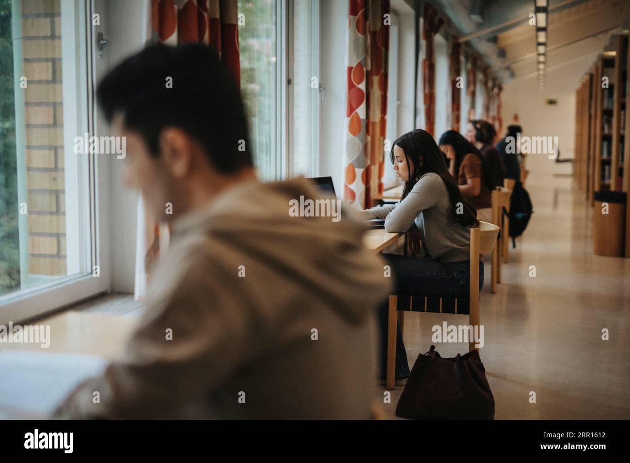 Students studying at table in library of university Stock Photo - Alamy