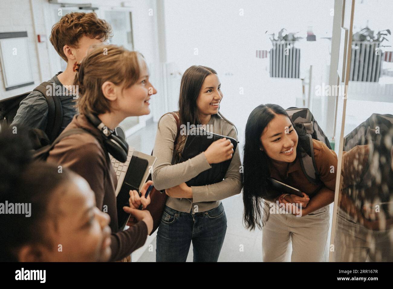 Cheerful multiracial male and female students checking result on ...
