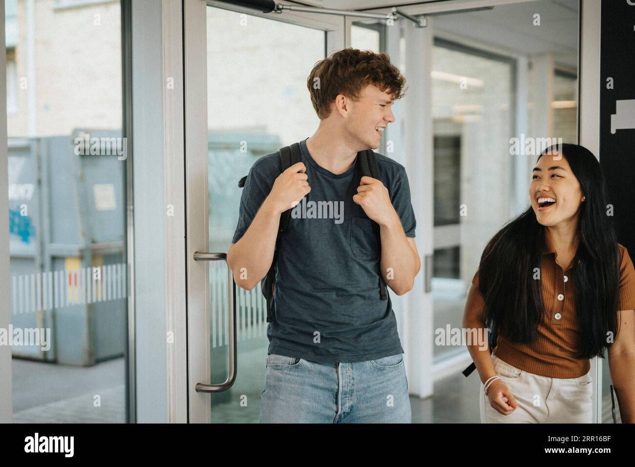 Cheerful male and female students entering classroom in university Stock Photo - Alamy