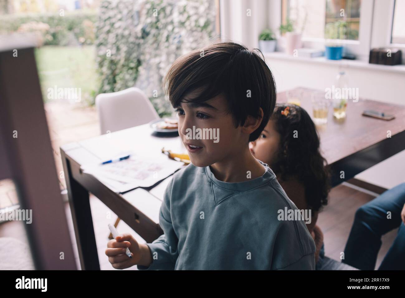 Boy drawing in living room at home Stock Photo - Alamy