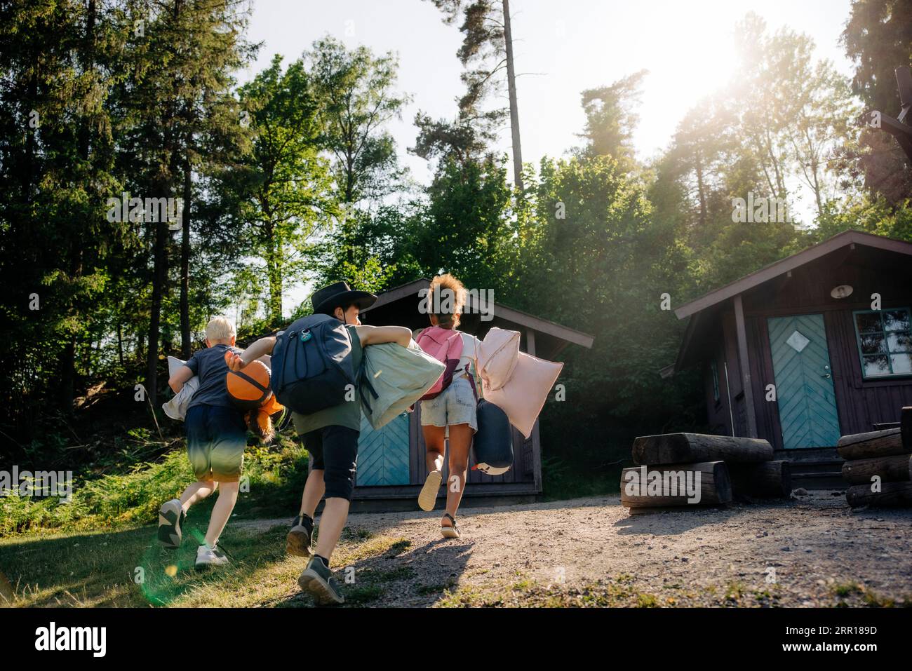 Rear view of happy kids running towards cabins at summer camp Stock ...