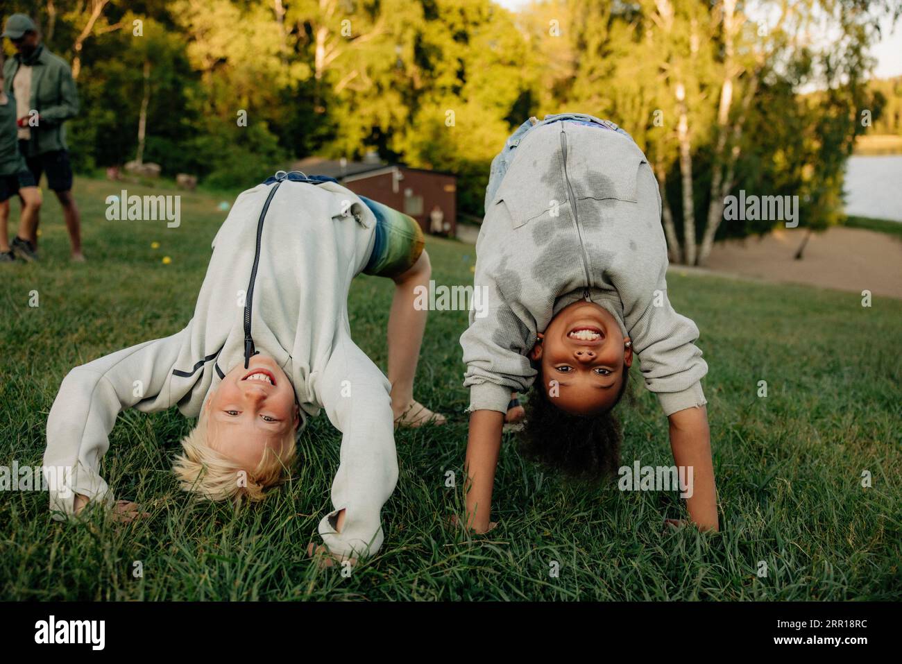 Portrait of playful male and female friends doing bridge position on ...