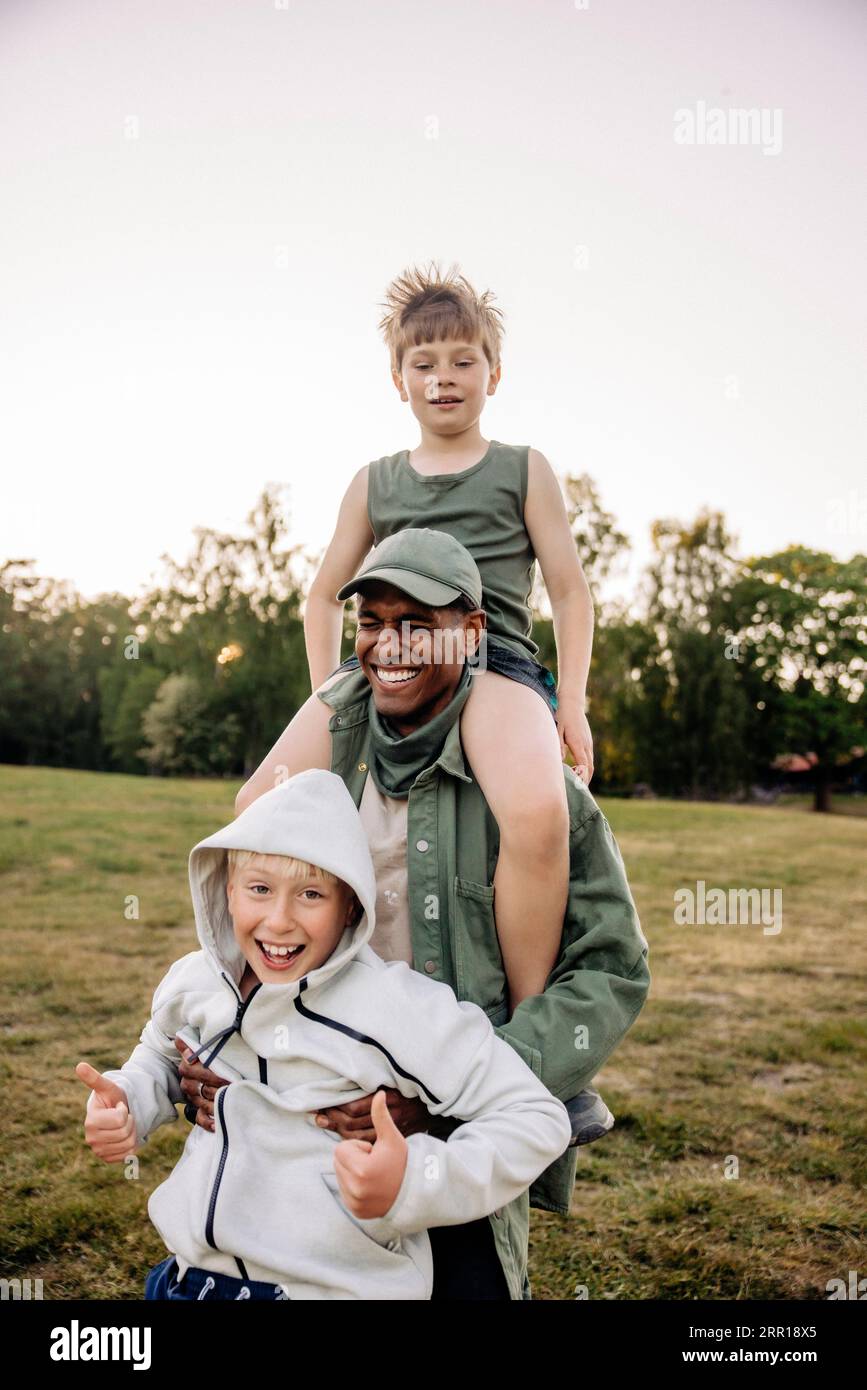 Happy boys having fun with male camp counselor in playground Stock ...