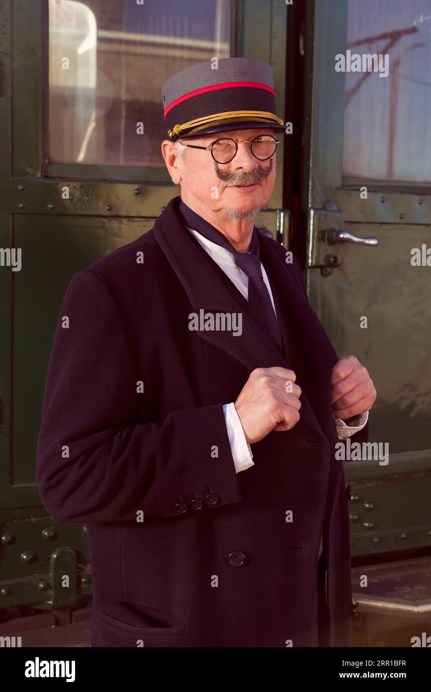 Reenactment scene of a vintage railway conductor at the departure of ...