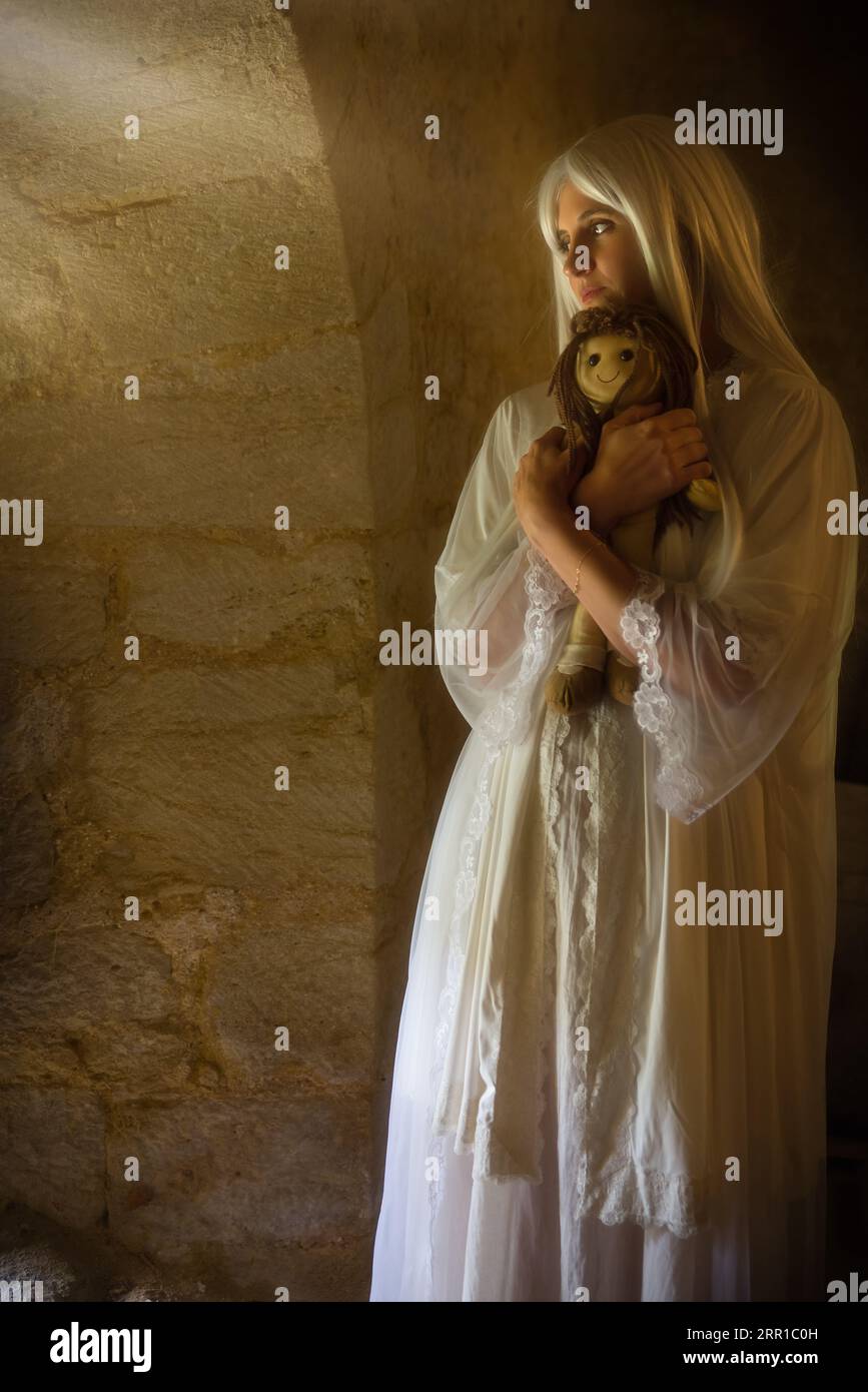 Female ghost wearing antique white nightgown holding a creepy doll ...