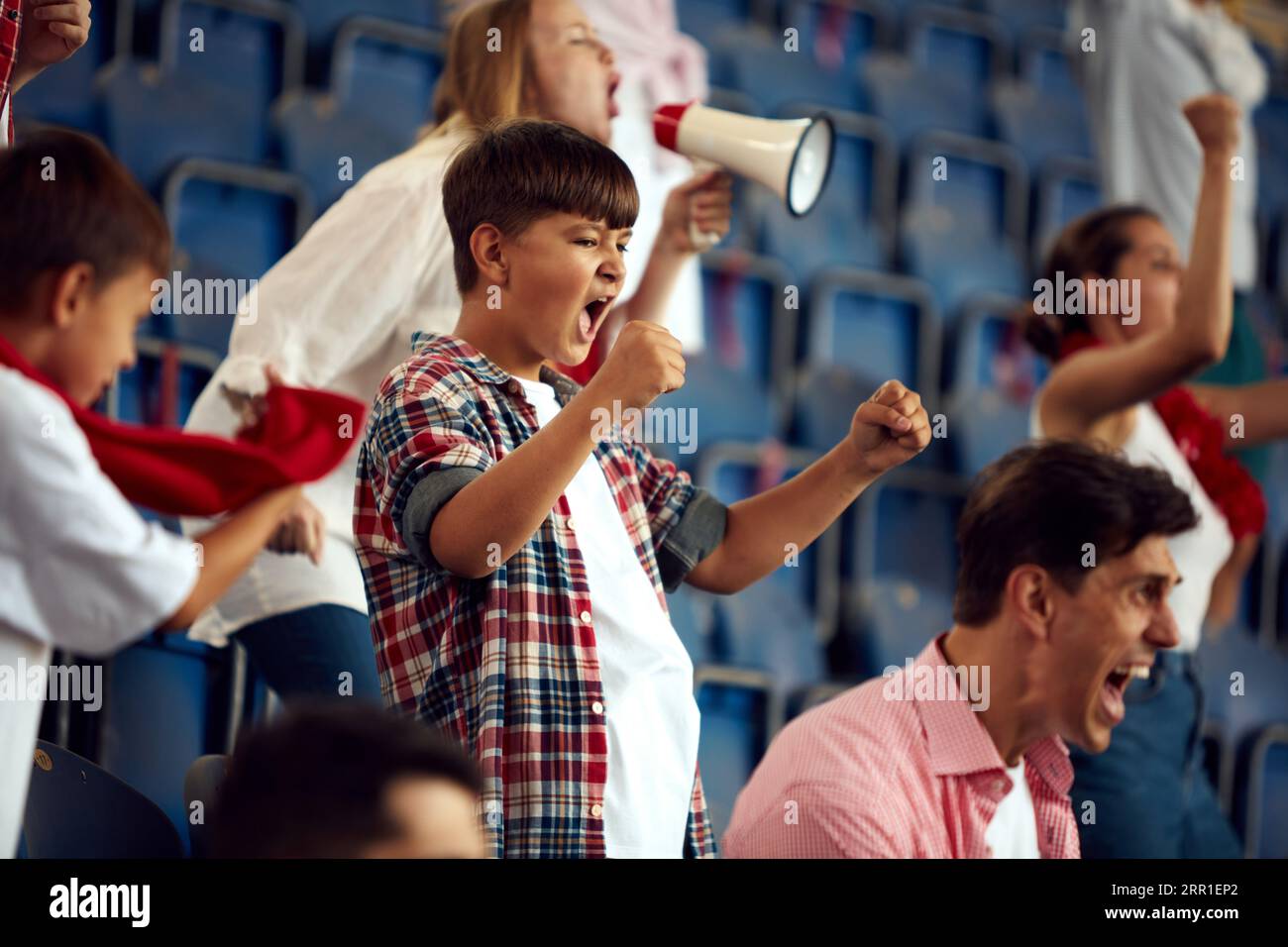 Young people and children attending live football match, loudly ...