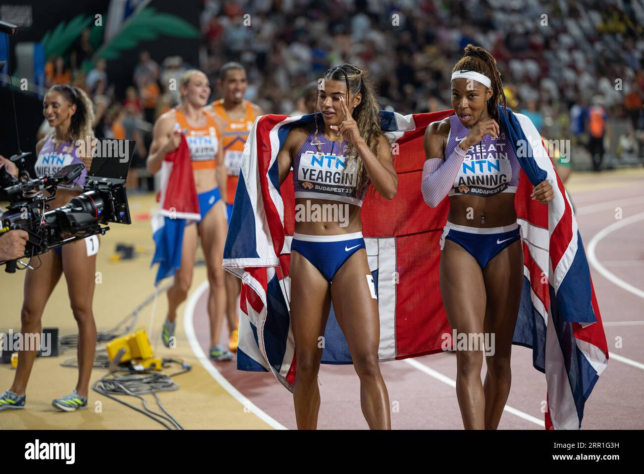 Amber Anning and Nicole Yeargin with her country's flag in the 4x400 ...