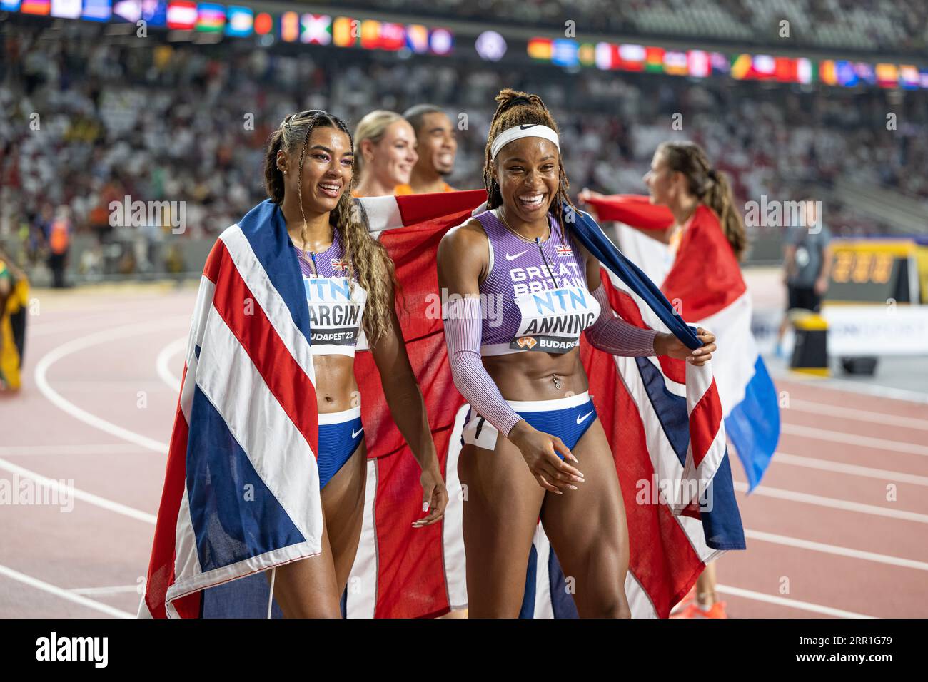 Amber Anning and Nicole Yeargin with her country's flag in the 4x400 ...