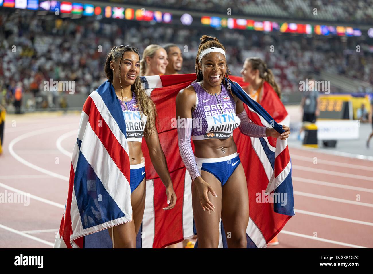 Amber Anning and Nicole Yeargin with her country's flag in the 4x400 ...